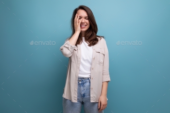 modest brunette young female adult in a shirt and jeans covered her ...
