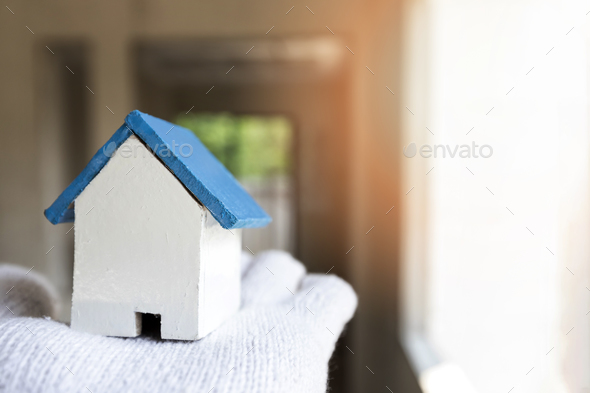House model in a worker hand. Architectural concept. Stock Photo by ...