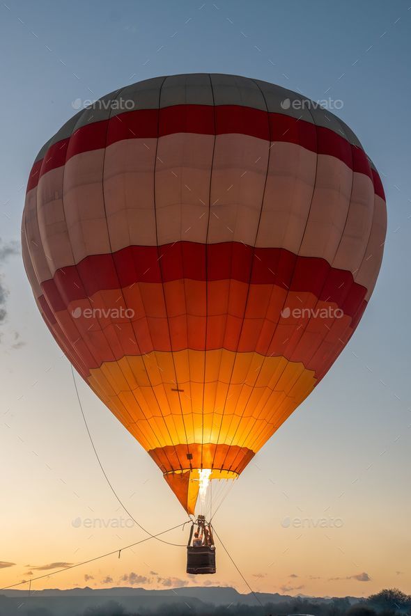 Aerial view of a colorful hot air balloon drifting through the sky ...