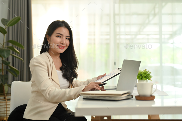 Gorgeous asian female entrepreneur sitting in front of laptop computer ...