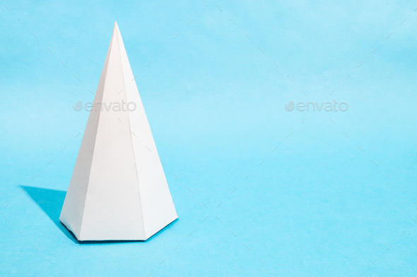 hand-crafted paper six-sided pyramid on turquoise Stock Photo by vvoennyy