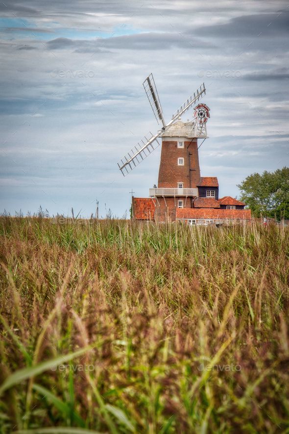 Idyllic countryside scene of a traditional windmill in a green field ...