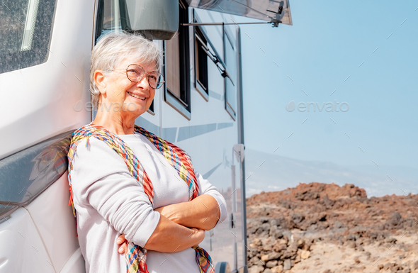 Happy retired senior woman outdoor her camper van vehicle enjoying free ...