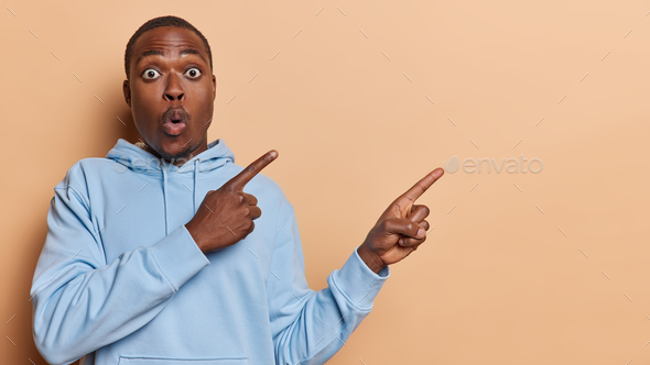 Horizontal shot of handsome dark skinned guy in state of utter shock ...