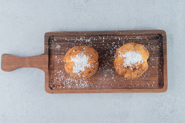 Cupcakes with vanilla powder toppings on a tray on marble background ...