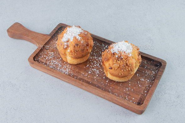 Cupcakes with vanilla powder toppings on a tray on marble background ...