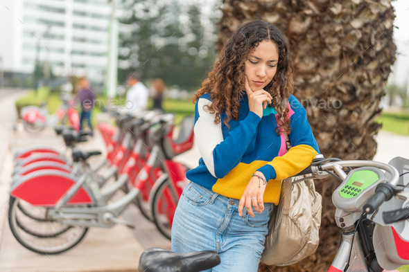 Woman thinking about riding a bicycle Stock Photo by GSR-PhotoStudio