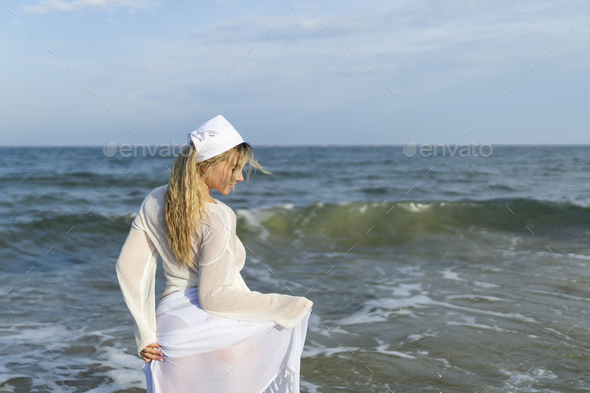 Beautiful girl in the sea. The woman enters the sea. Blue ocean. Girl ...