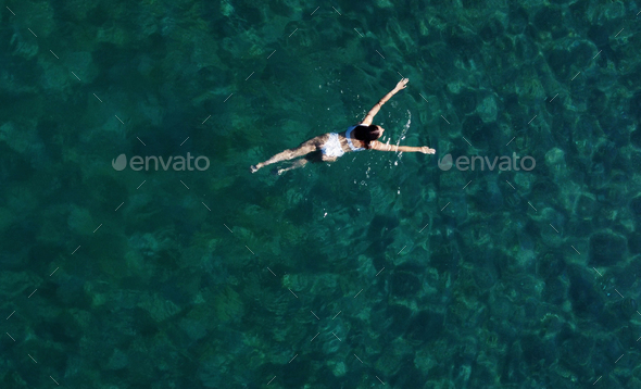 Above view of woman swimming at sea. Aerial top view of young girl in ...