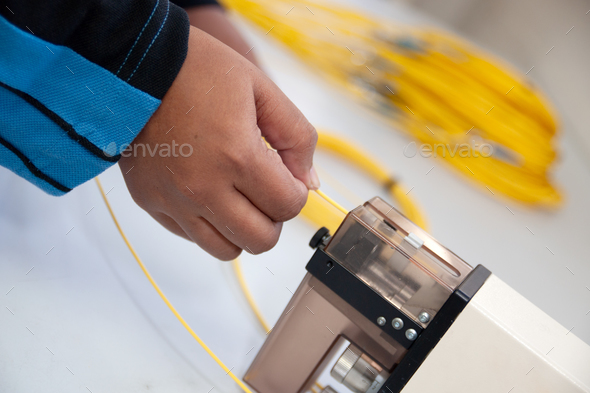 Technician cleaving an optical fiber, a crucial process for a good ...