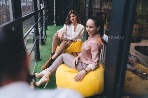 Positive women chilling on balcony in office Stock Photo by GaudiLab