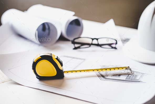tape measure is placed on the work table with a house plan designed ...
