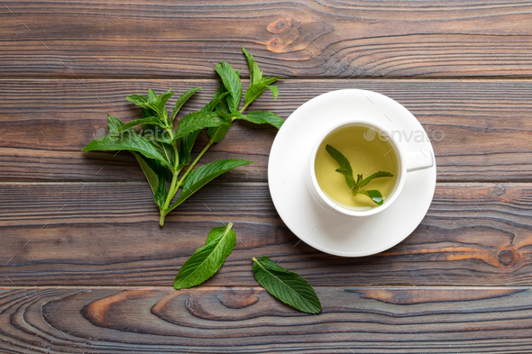 Cup of mint tea on table background. Green tea with fresh mint top view ...