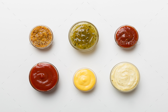 Different types of sauces in bowls on a colored Board . Top view ...