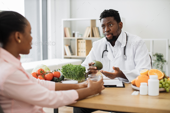 Food expert showing microgreens to female client in clinic Stock Photo ...