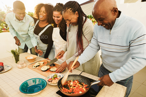 Happy african family cooking outdoor at home rooftop terrace during ...