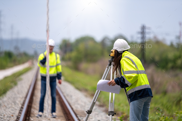 Surveyor engineers team wearing safety uniform and blueprint checking ...