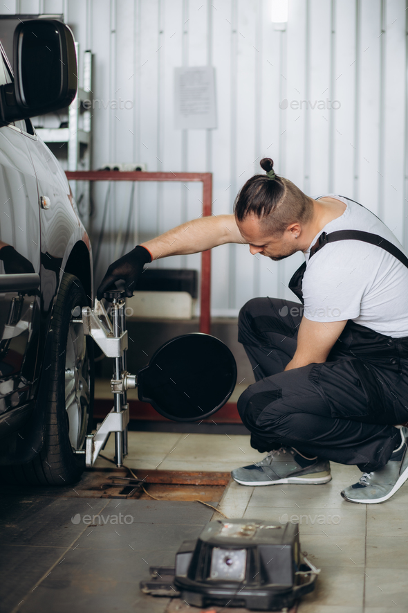 Auto mechanic from Equipment for cambering wheels on a car. Stock Photo ...