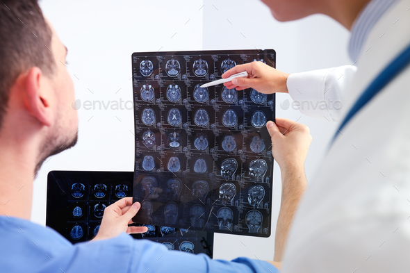 Doctors look at MRI images of a human head Stock Photo by AtlasComposer