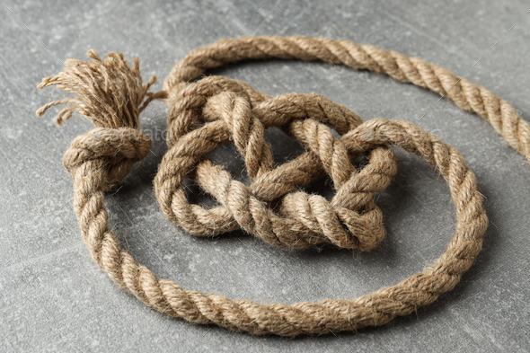 Thick knotted rope close-up on gray background Stock Photo by AtlasComposer