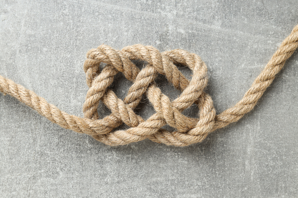 Thick knotted rope close-up on gray background Stock Photo by AtlasComposer