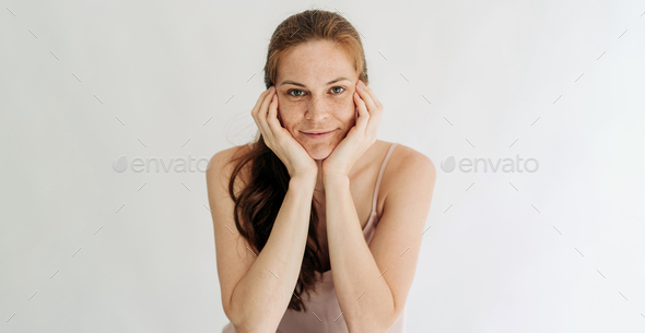 Red-haired authentic young woman leaned her head on her hand, white ...