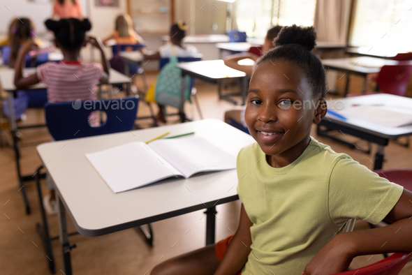 Portrait of happy african american schoolgirl in diverse elementary ...