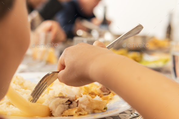 Child eating fish, rice and asparagus at home with his family Stock ...