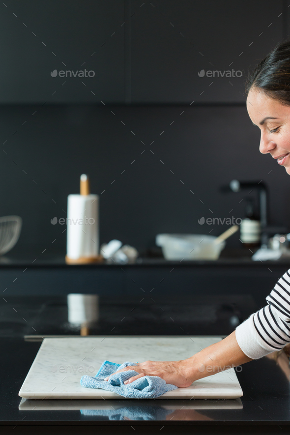 Woman cleaning the table while cooking at the kitchen Stock Photo by ...