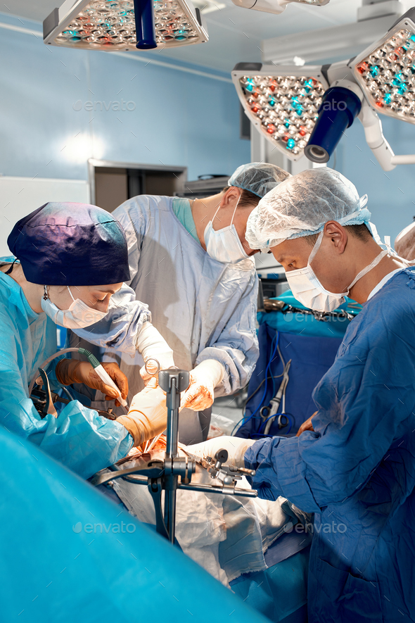 Surgeons team during complex surgical operation in a sterile operating ...