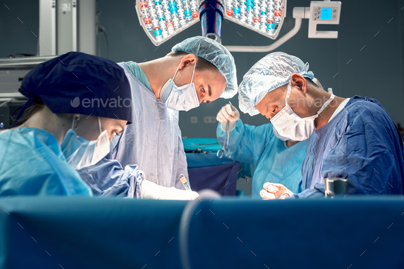 Surgeons team during complex surgical operation in a sterile operating ...