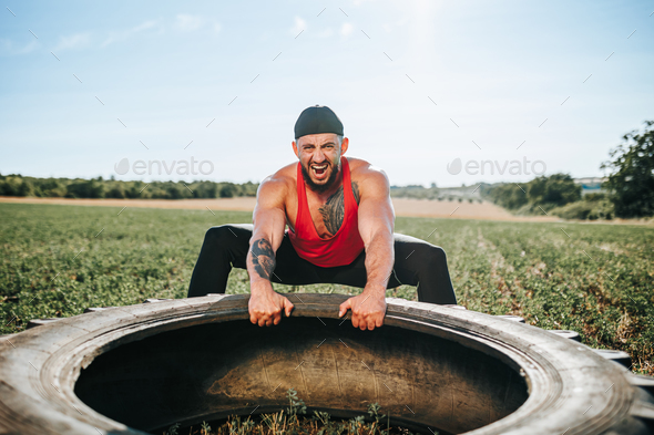 Muscular Male Engaged in CrossFit Wheel Pull Exercise Outside Stock ...