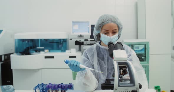 A Scientist in Sterile Clothing Looks Through a Microscope, Stock Footage