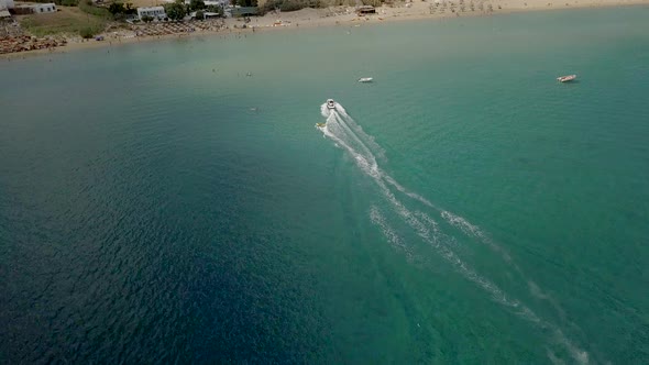 A speedboat approaches Golden Beach after pulling a passenger on a tube ...