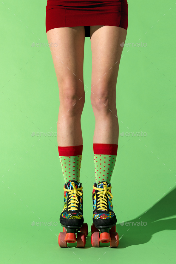 Crop fit lady in roller skates standing in green studio Stock Photo by ...