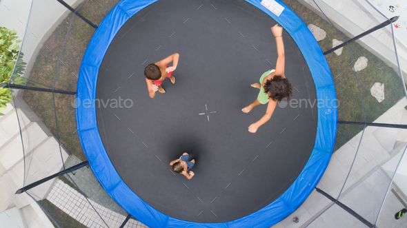Children playing on trampoline aerial view Stock Photo by Zurijeta