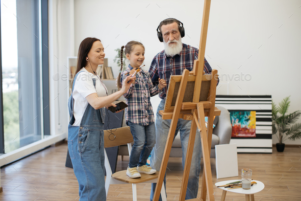 Artistic family dancing for music while painting in room Stock Photo by ...