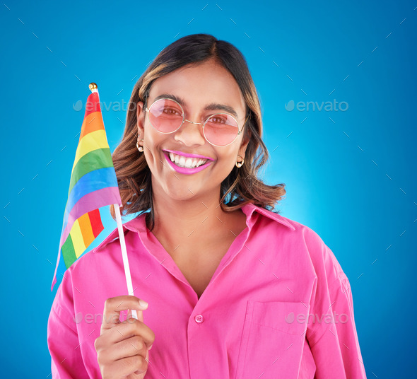 Woman, lgbtq and rainbow flag in studio portrait, sunglasses and sign ...