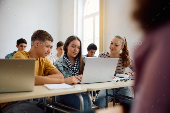 High school classmates using laptop during computer class in the ...