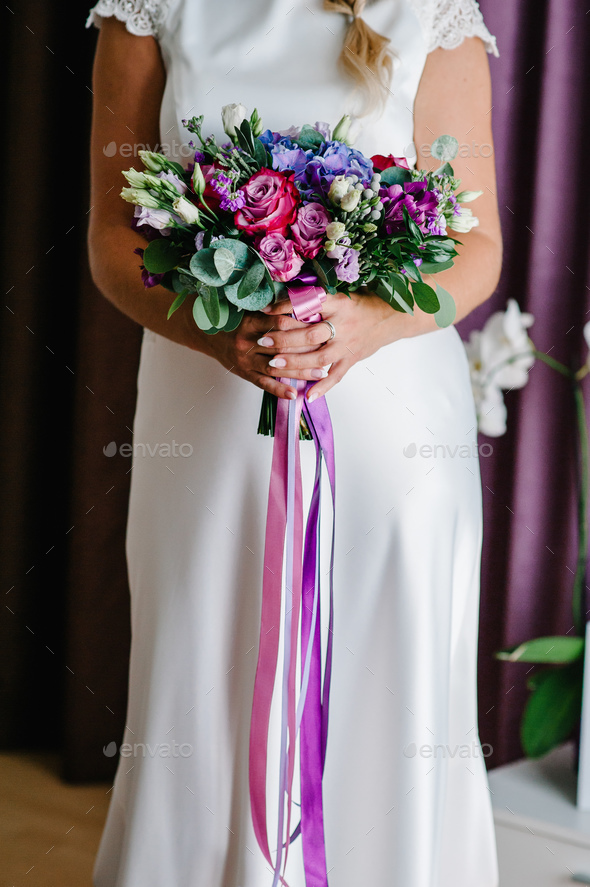 Bride showing off her beautiful bouquet of pink, violet, purple flowers ...