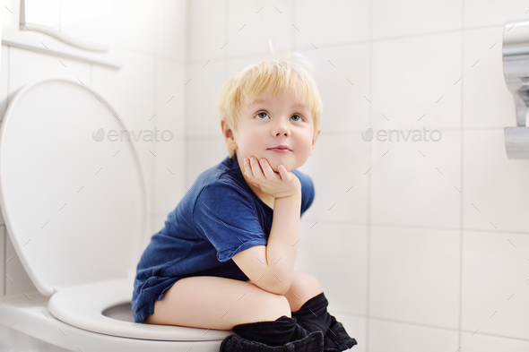 Cute little boy in restroom. Toddler child is training use toilet ...