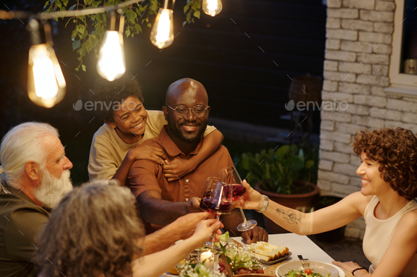 Happy young man with son toasting with his wife over served table Stock ...