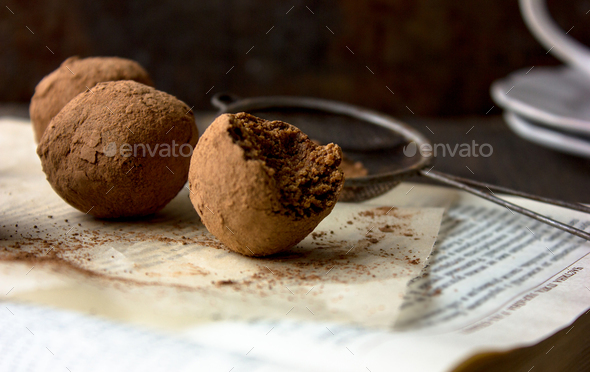 Cocoa powder is sprinkled on a chocolate truffle under a beautiful ...