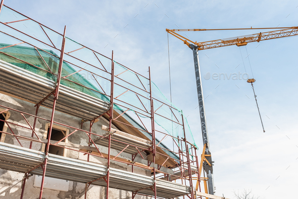 Building armor for house under restoration and crane. Stock Photo by ...