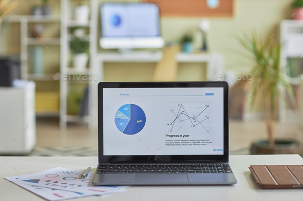 Open laptop computer with statistics data charts on screen on office ...