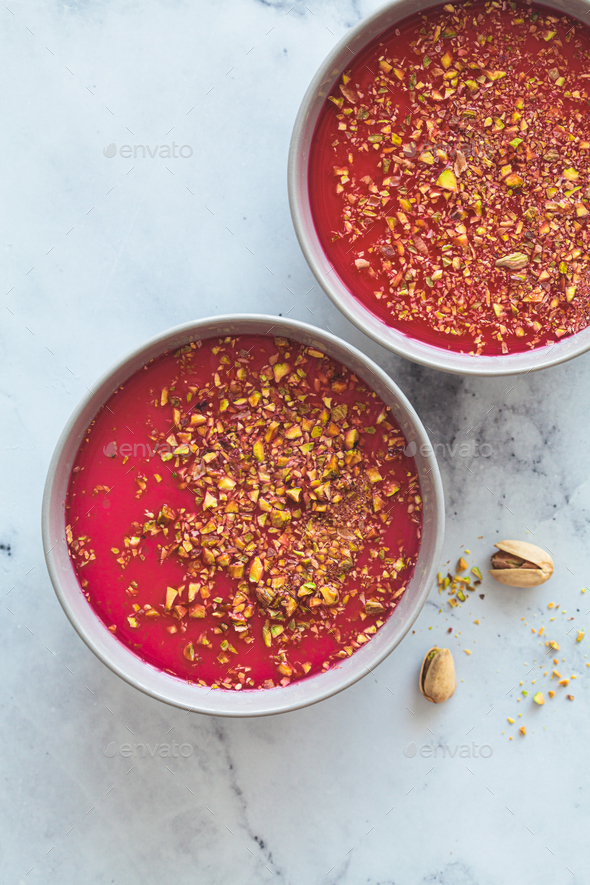 Malabi traditional Arabic dessert. Milk pudding with pink syrup and ...