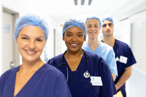 Portrait of diverse group of healthcare workers wearing surgical caps ...