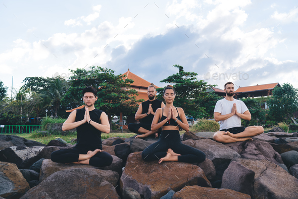 Tranquil male and female concentrated on namaste asana enjoying harmony ...