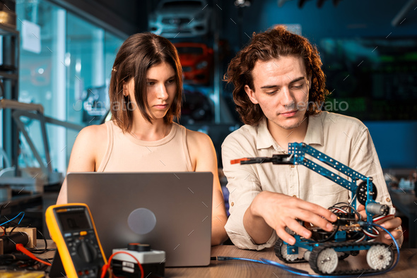 Young man and woman doing experiments in robotics in a laboratory Stock ...