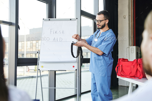 paramedic in eyeglasses and blue uniform standing at flip chart with ...